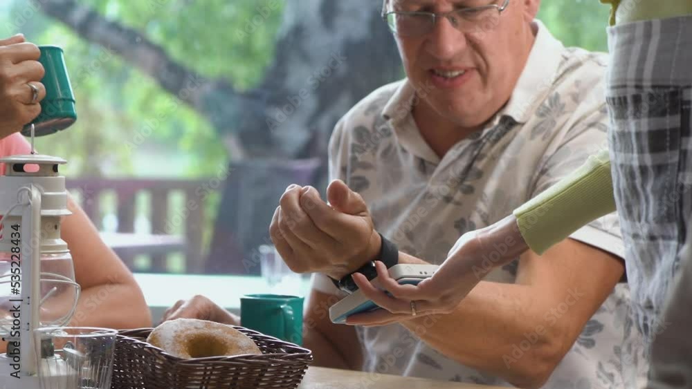 Vidéo Stock An elder man pay the bill with smart watch wirelessly on ...