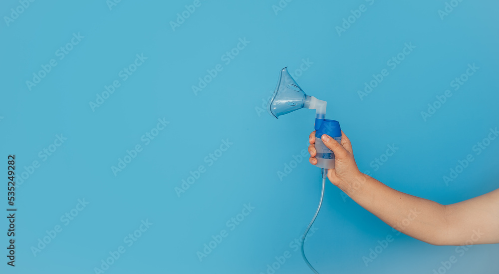 Medical inhaler in hand on a blue background , asthma disease treatment ...