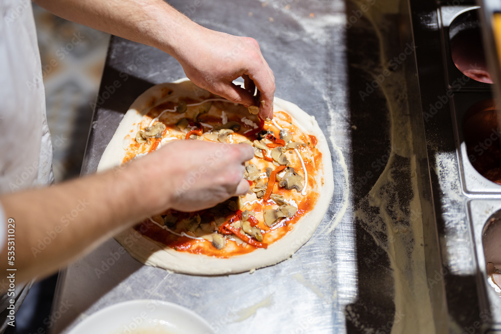 Pizza making process. Male chef hands making authentic pizza in the ...