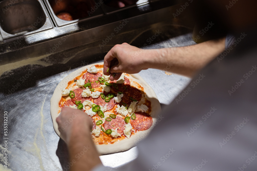 Pizza making process. Male chef hands making authentic pizza in the ...