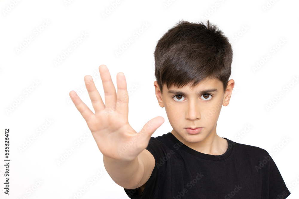 Little caucasian kid standing with outstretched hand showing stop sign ...