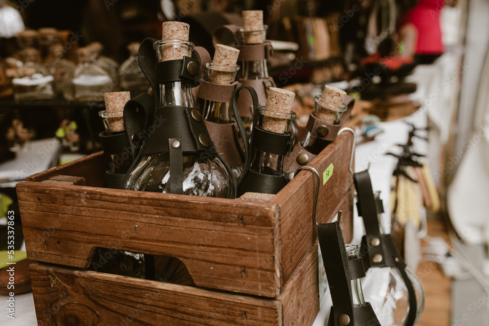 Wooden box of potion bottles with (leather holders) on a market stall ...