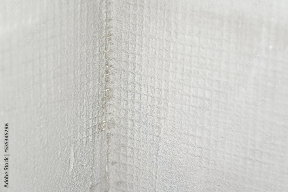 Bare wall in new house construction site with plastic reinforcement net ...