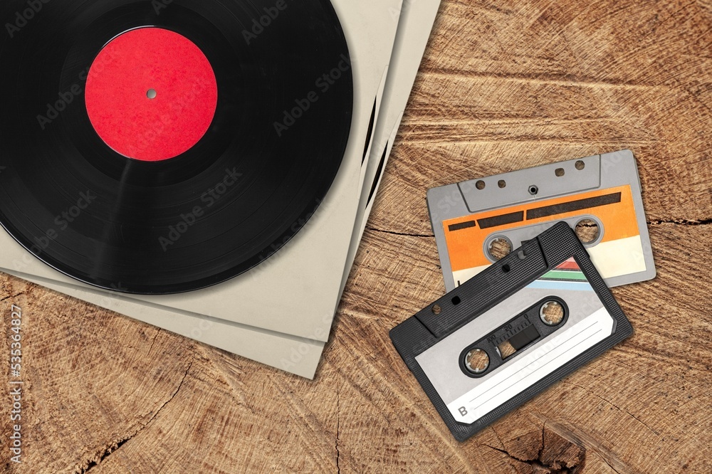 Vinyl records, cassette tapes and cassette recorder on table. Retro ...