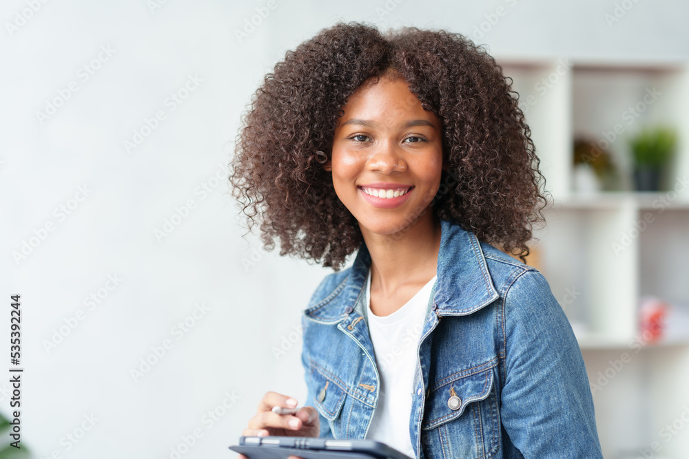 Foto de Beautiful American women student studying online takes notes on ...