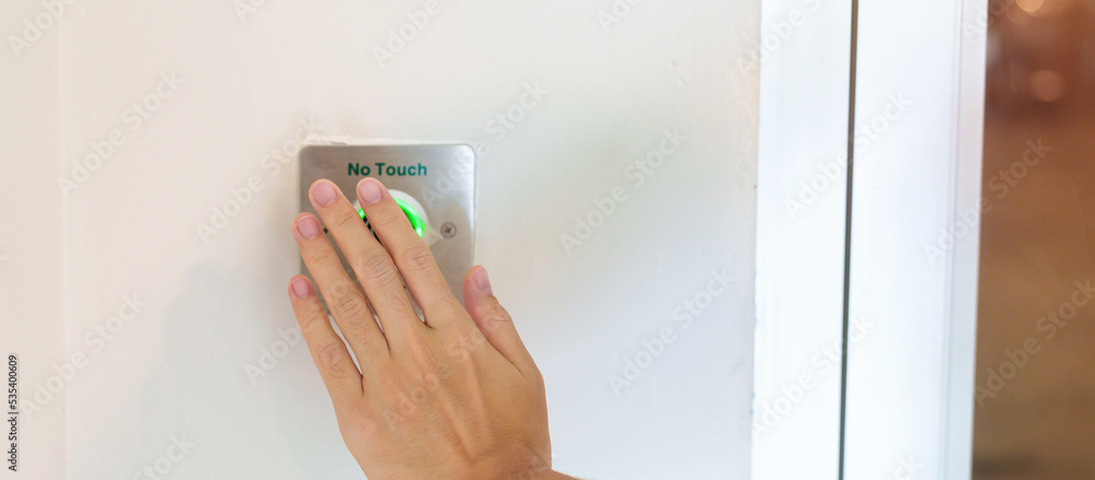 Hand open the door by No touch sensor switch on the wall at office or ...