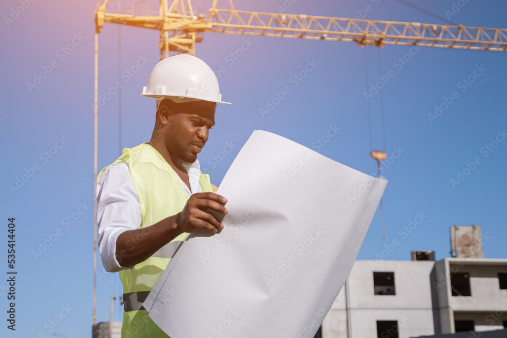 African American architect compares building construction to drawings ...