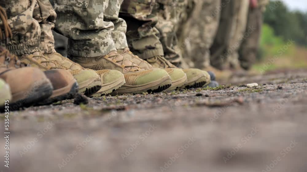 Close-up of legs of army soldiers in camouflage uniforms and boots ...