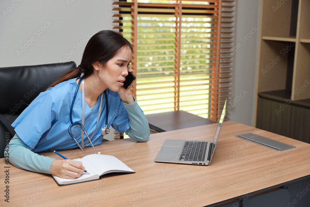 Happy caregiver nurse using smart mobile phone with computer, she ...