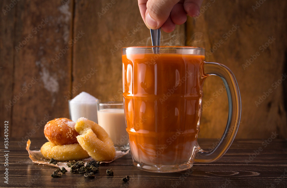 original hot thai milk tea drink with sweet donuts , thai beverage ...