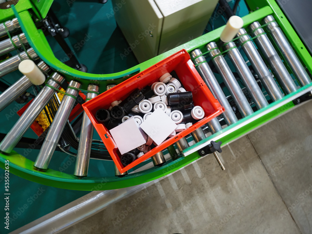 Manufacturing line. Box with plastic parts on conveyor. Modern ...