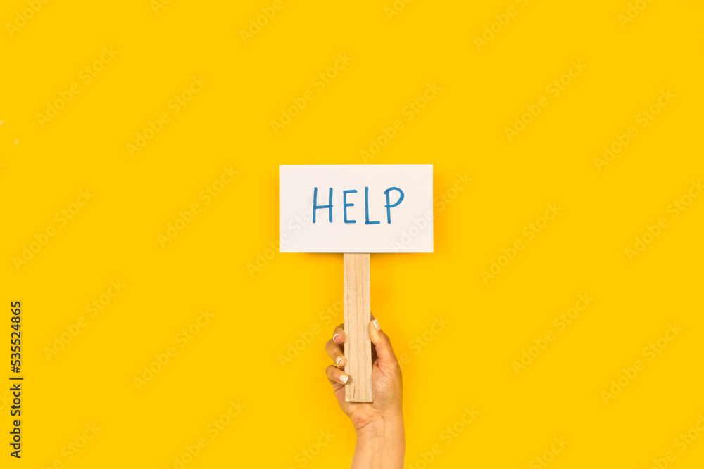 Mano de mujer sosteniendo un cartel con la palabra Help sobre un fondo ...