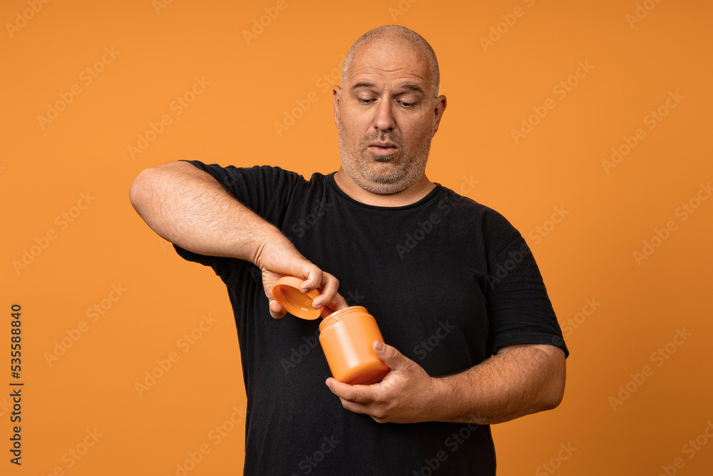 the gray-haired man wants to rub himself with his ointment, he put his ...