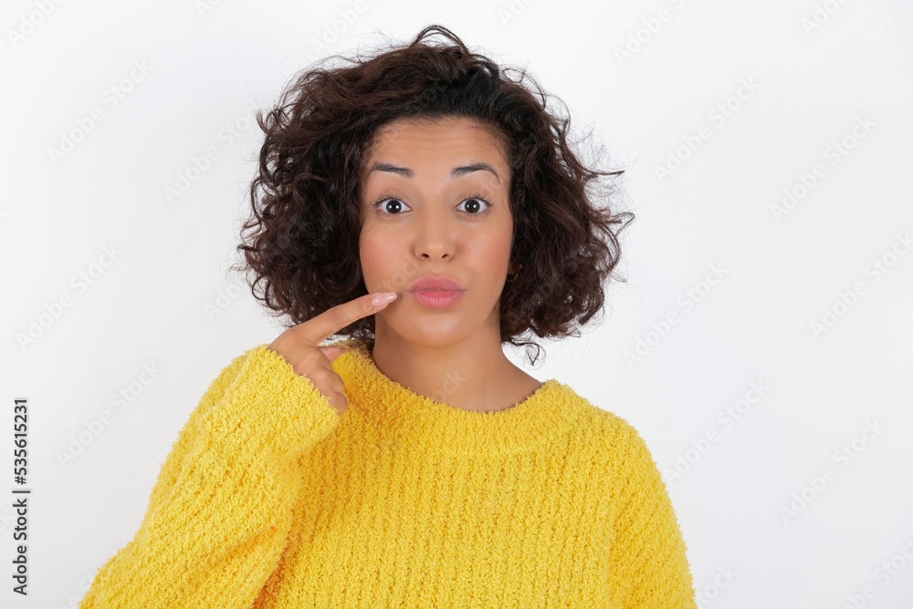 Charming young beautiful woman with curly short hair wearing yellow ...