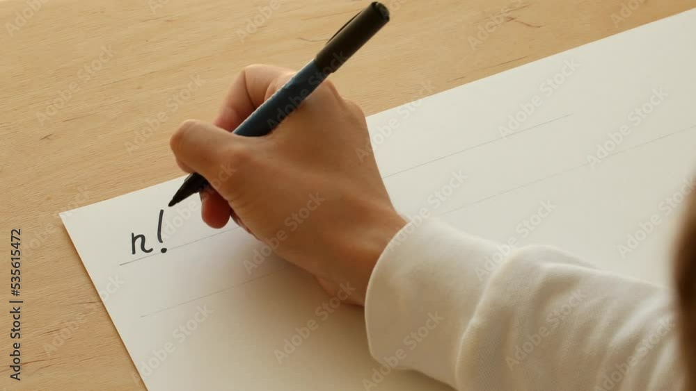 Hand of a young mathematician writing formula for factorial function ...