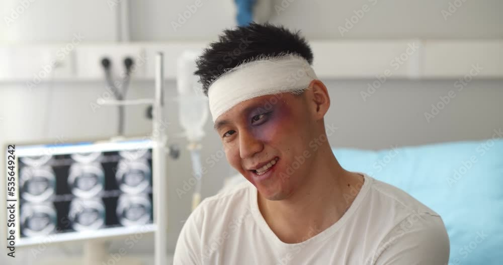 Male patient with bandaged head and bruised face acting crazy in ...
