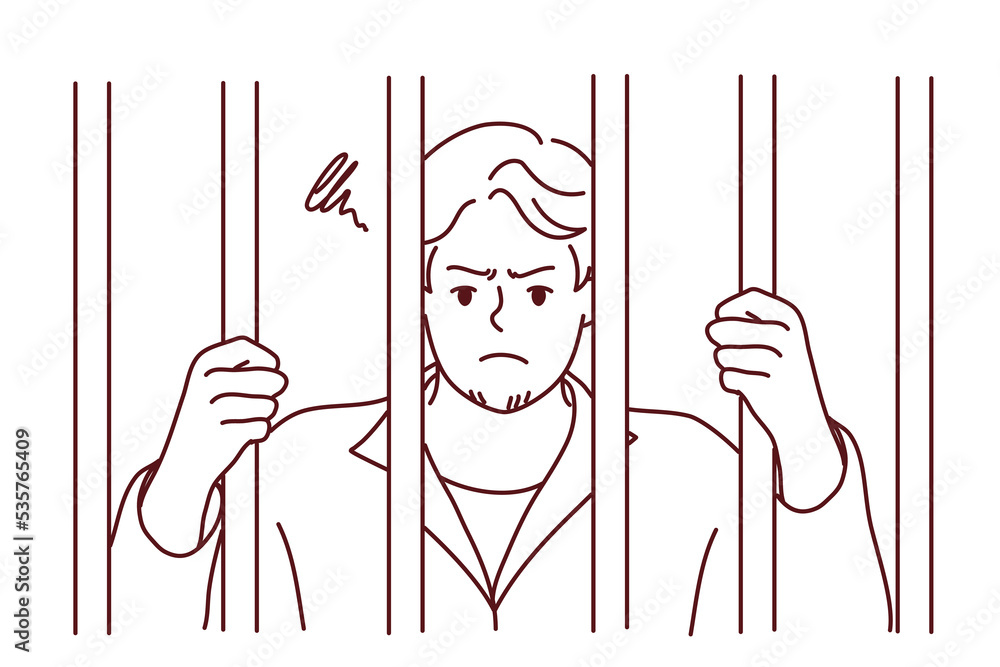 Unhappy man in robe behind bars in jail. Angry male criminal imprisoned ...