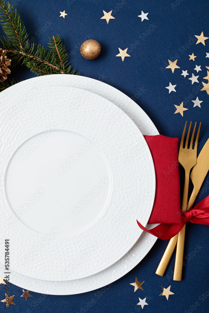 Festive christmas table setting with golden cutlery and porcelain plate ...