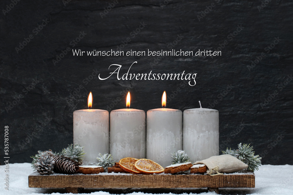 Dekoration zum dritten Advent. Drei brennende Kerzen mit Zimtsternen ...