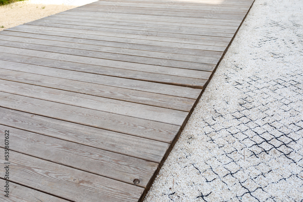 Wooden walkway, pedestrian path made of fine gravel reinforced with ...