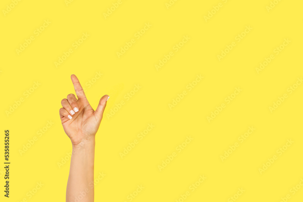 Mano de mujer con el brazo y la mano levantada apuntado con el dedo ...