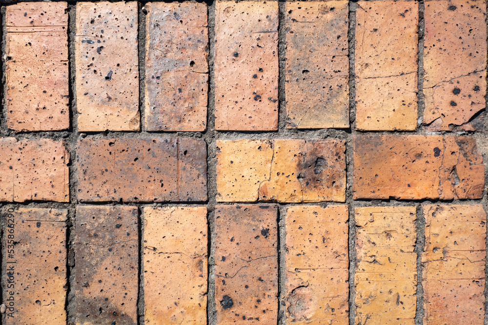 Calçada com pequenos blocos retangulares de barro sobrepostos lado a ...