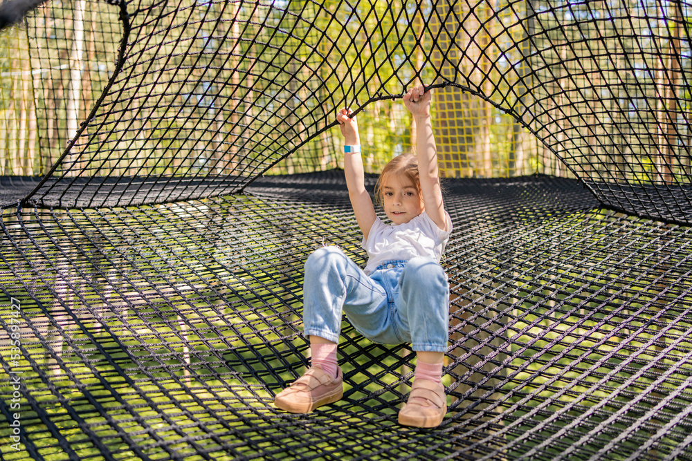 child having fun in net tunnel in playground or amusement park. Stock ...