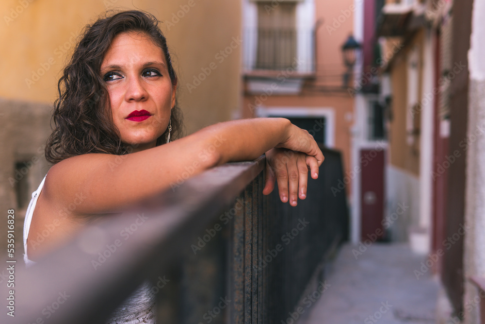 Foto Stock Brunette woman leaning with her arms on a railing as she ...