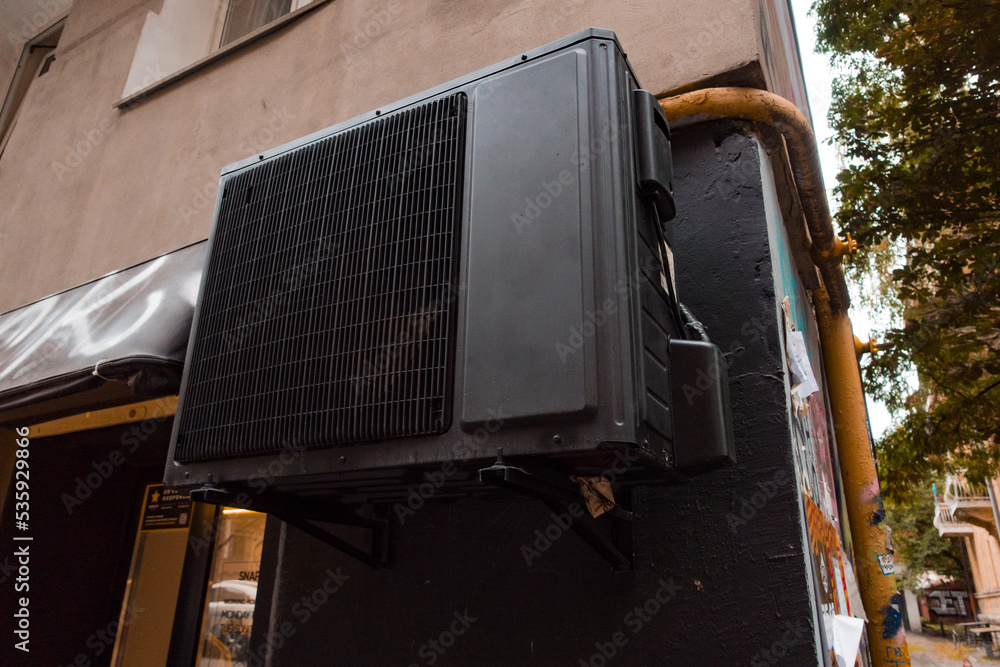 Black air-conditioner hanging on the facade of the building. Structure ...