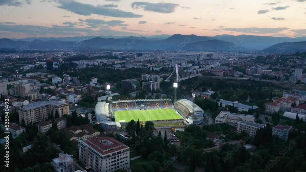 Vidéo Stock Cityscape featuring a stadium with green grass soccer field ...