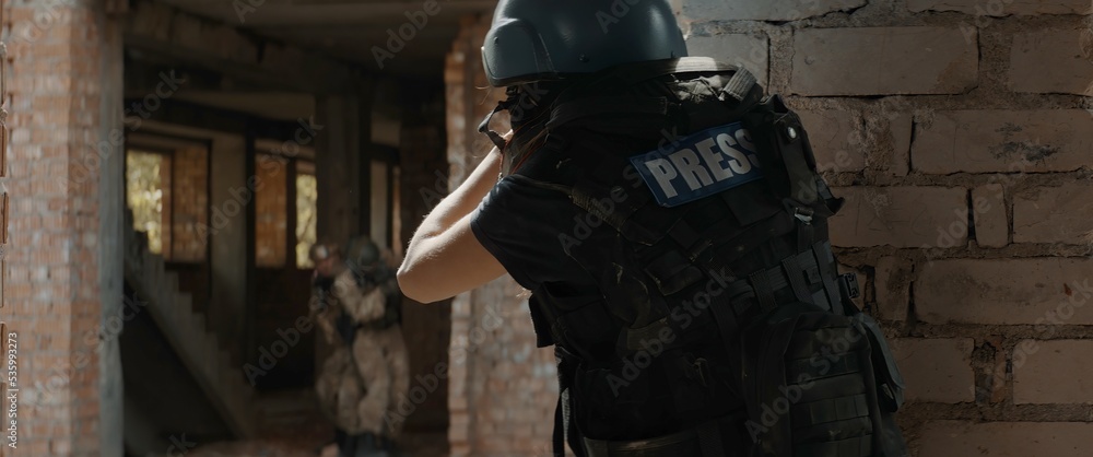 Caucasian female war journalist wearing protective helmet and ...