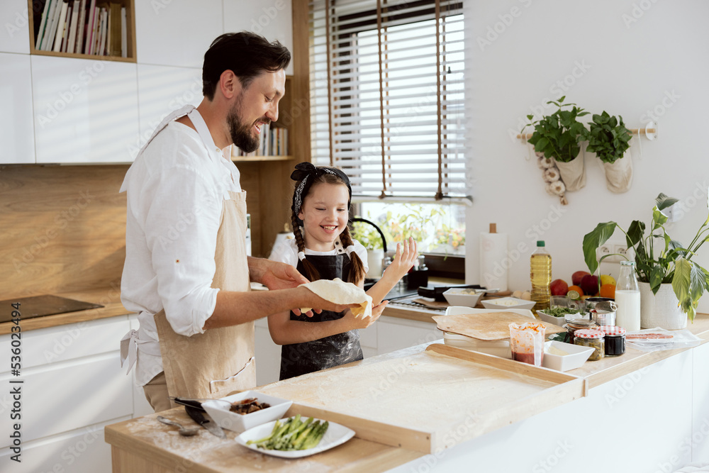 Happy father dad with beared throwing up dough teaching daughter ...