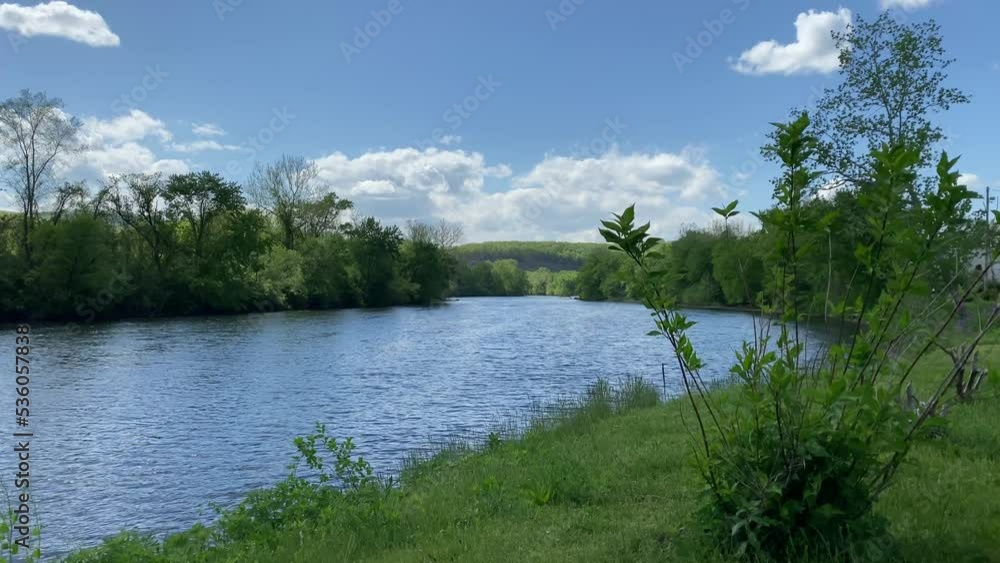 hot summer day with clouds and blue sky with flowing water way and wind ...