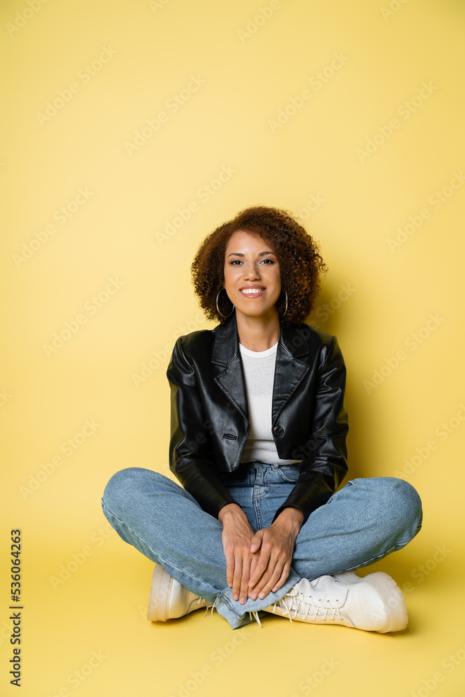 full length of pleased african american woman in leather jacket and ...
