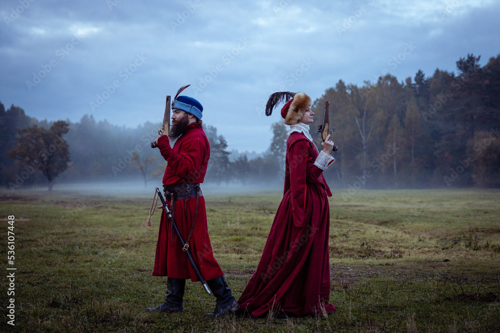 Duel of a man and a woman in 17th century costumes using antique ...