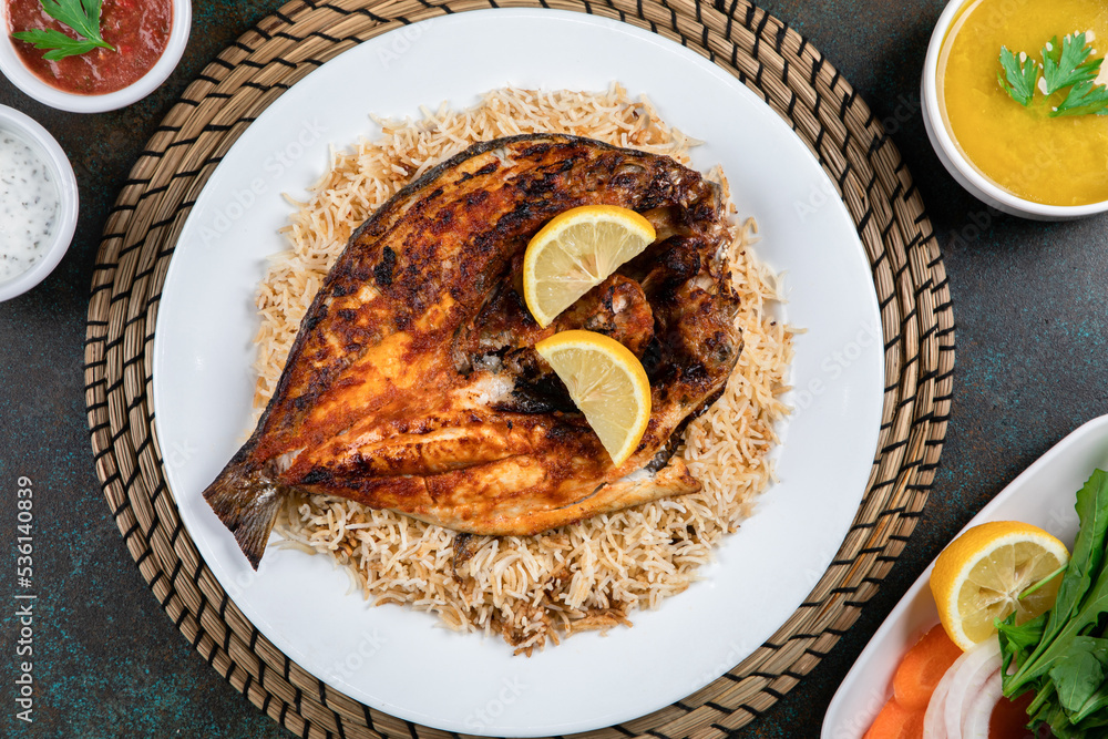Arabian Sheri fish mandi rice with lemon slice served in dish top view ...