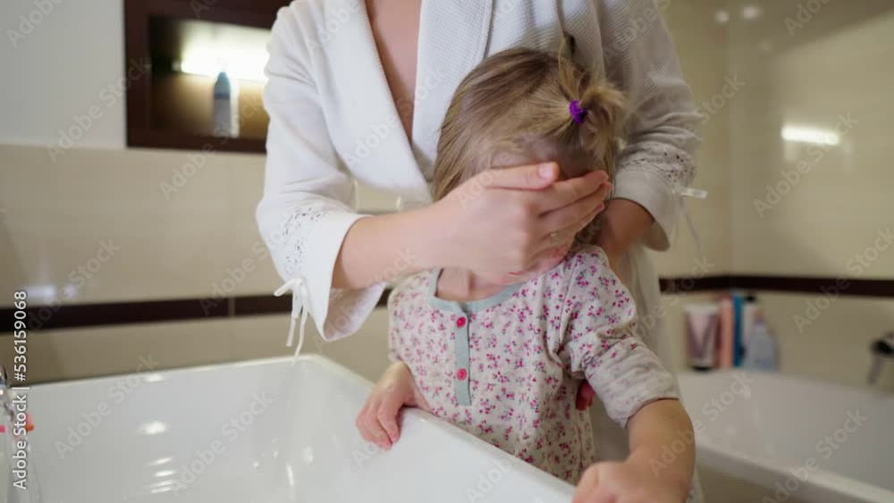 Mother Washes Her Daughter In The Bathroom In The Morning After Waiking