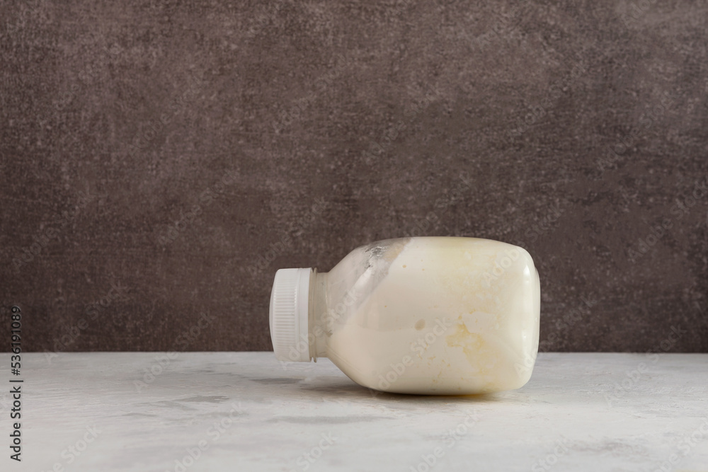 Spoiled curdled milk, bloated bottle. Concept - Improper storage of ...