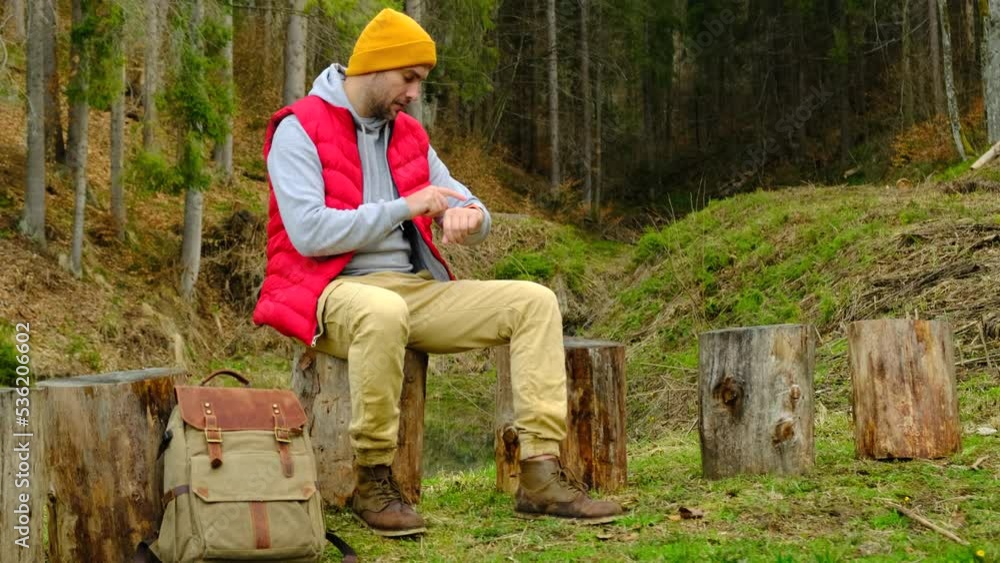 traveler looking at his smart watch. male hiker using smart bracelet ...
