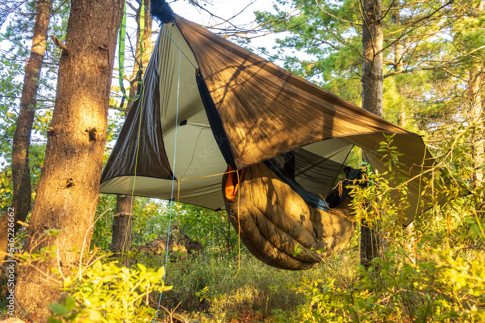 Ultralight hammock and quilt sleep system set up under a shaped tarp in ...