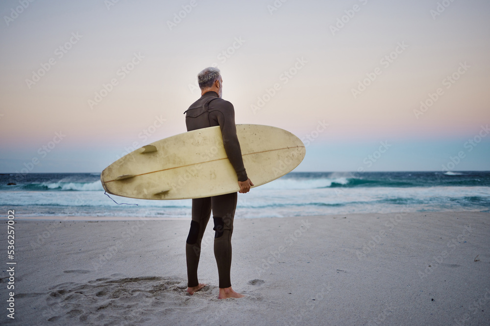 Surfer, surfboard and senior man on beach at sea waves in during sunset ...