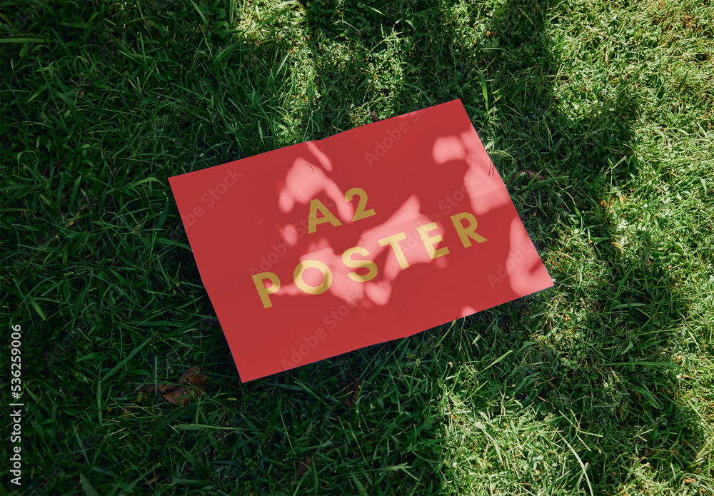 Horizontal A2 Poster Mockup Over Green Grass With Sunlight Shadows ...