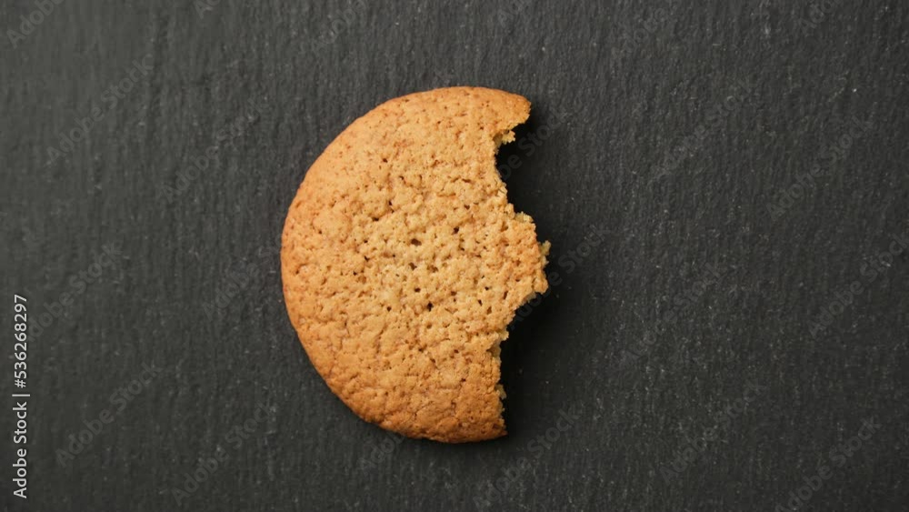 Oatmeal cookie eaten slowly. Disappearing chip cookie on black ...
