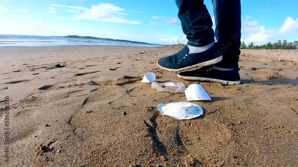 A Person throwing used plastic bottle and paper cup on beach video ...