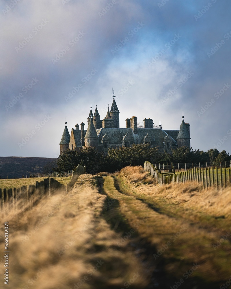 Vertical closeup of Veves Castle with yellow grass around and cloudy ...
