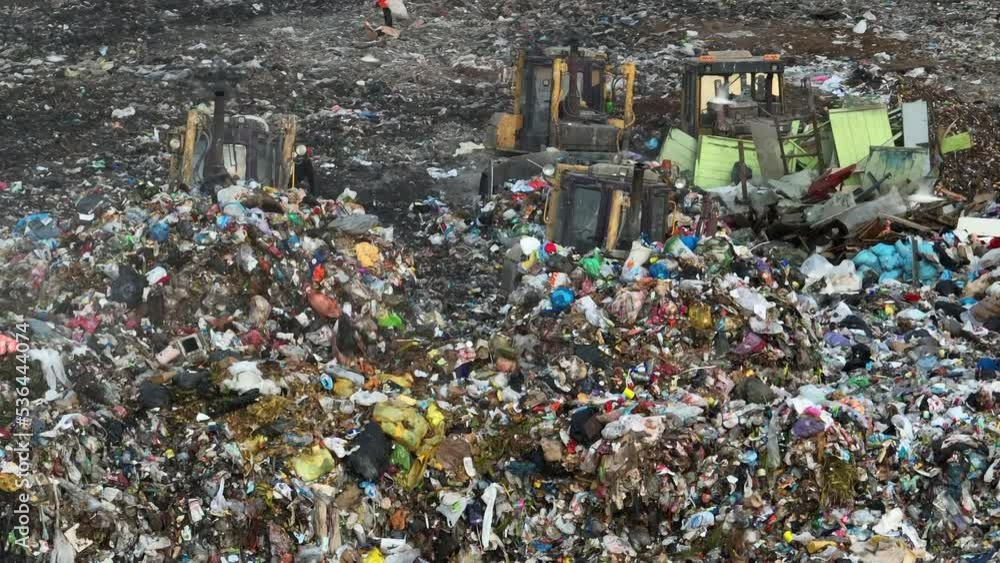 Dozer on landfill. Garbage dump with waste plastic, rubbish and ...