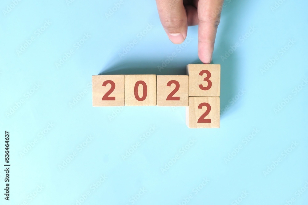 Hand changing year 2022 to 2023 in wooden blocks cubes in blue ...