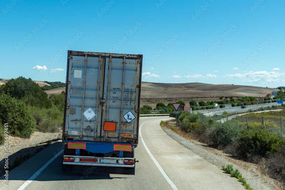 Truck circulating with a container marked with an orange panel ...