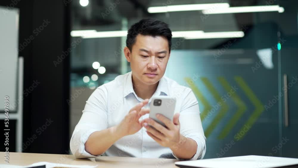 angry annoyed displeased asian business man in office using smart ...