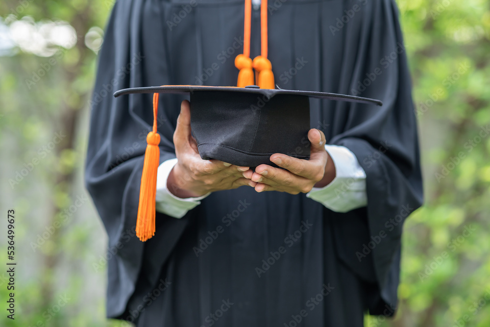 Close up hands of Graduate man holding graduation cap celebrating so ...